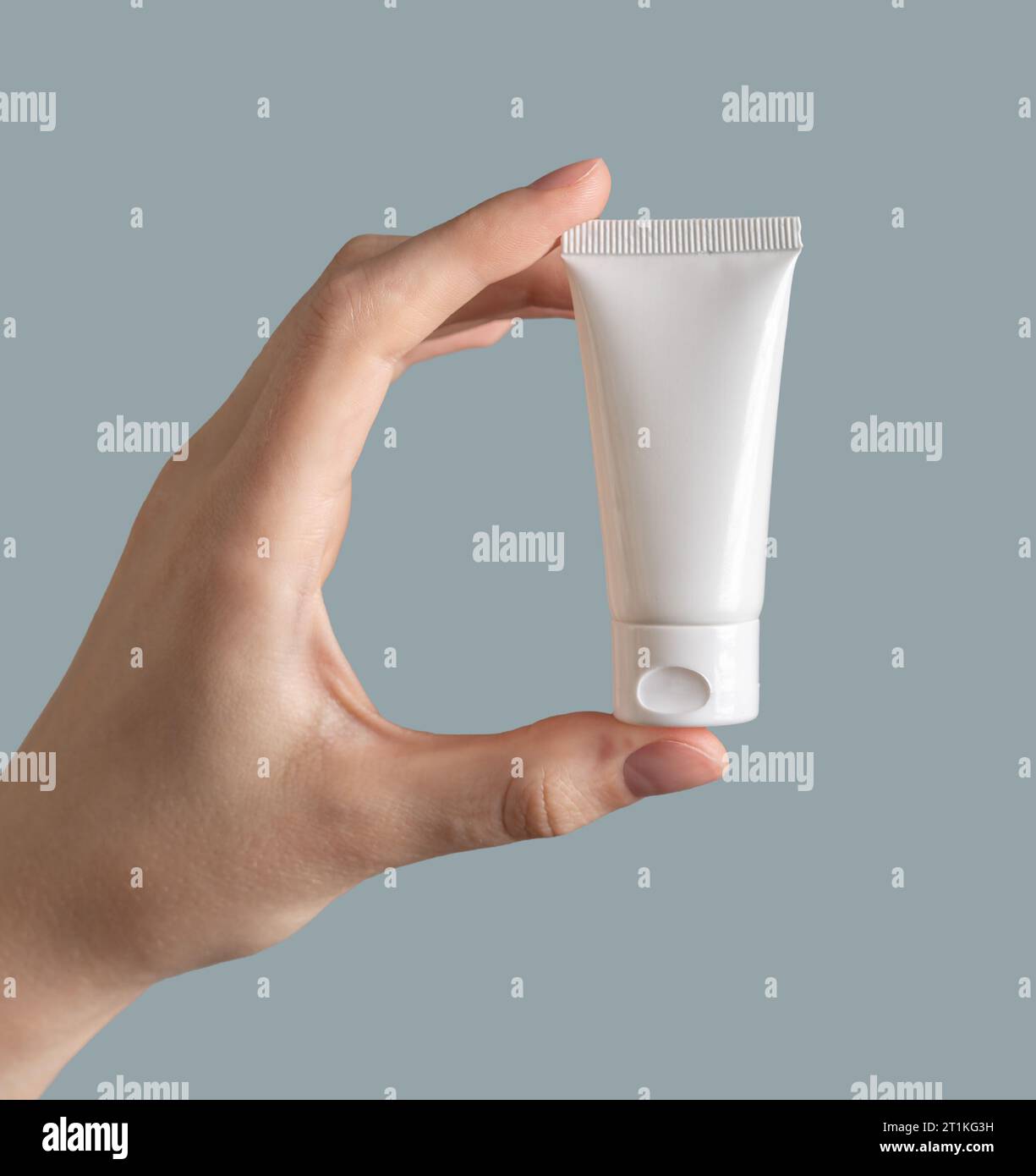 Cosmetic tube in hand isolated on white Stock Photo - Alamy