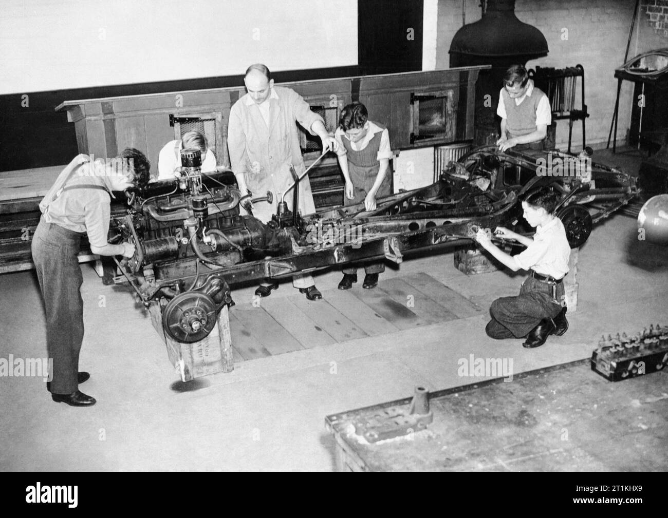A Modern County School Boys engaged in car maintenance as part of a ...