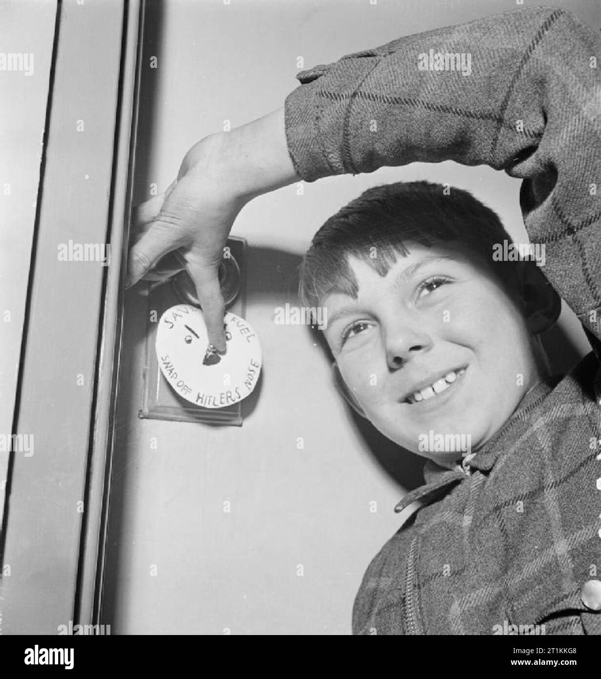 Fuel Economy in the Home, Britain, C 1942 A young boy plays his part in ...