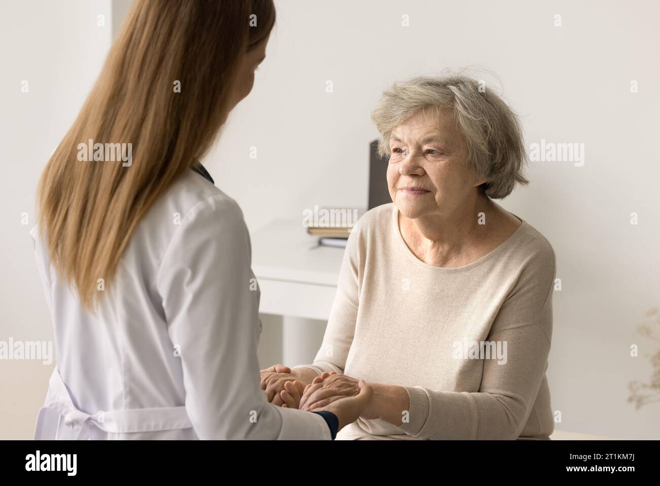 Caring young therapist in white uniform holding hands of patient Stock ...