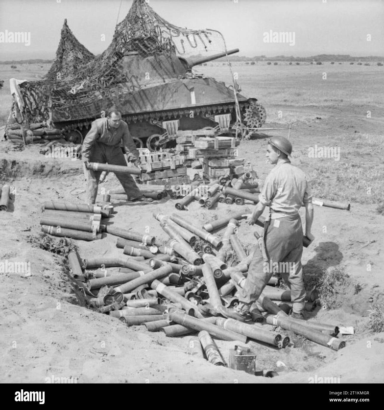 Empty 75mm HE shell cases being collected from Sherman tanks firing in ...