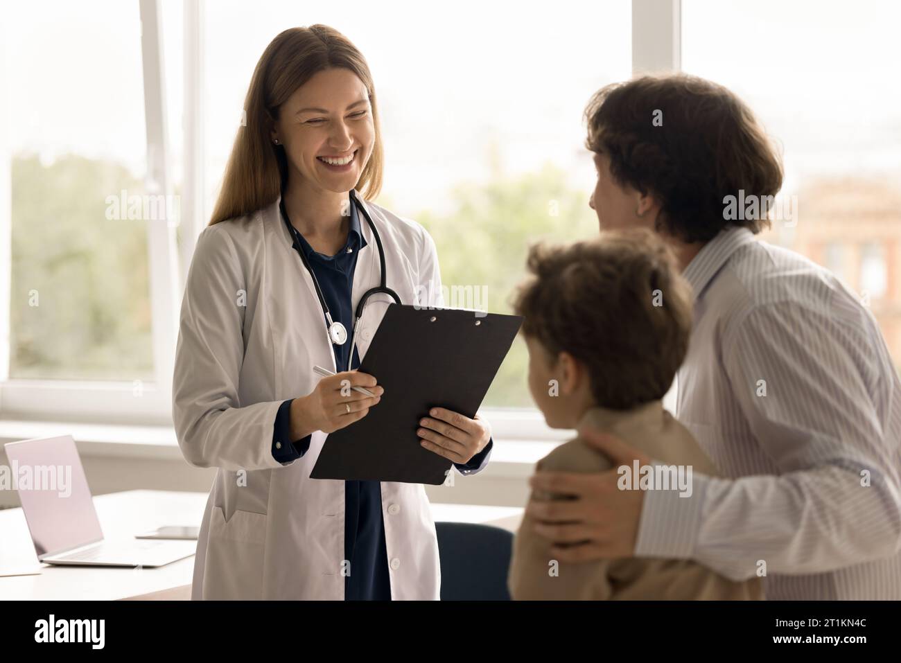 Child and father talk to pediatrician during visit at clinic Stock ...