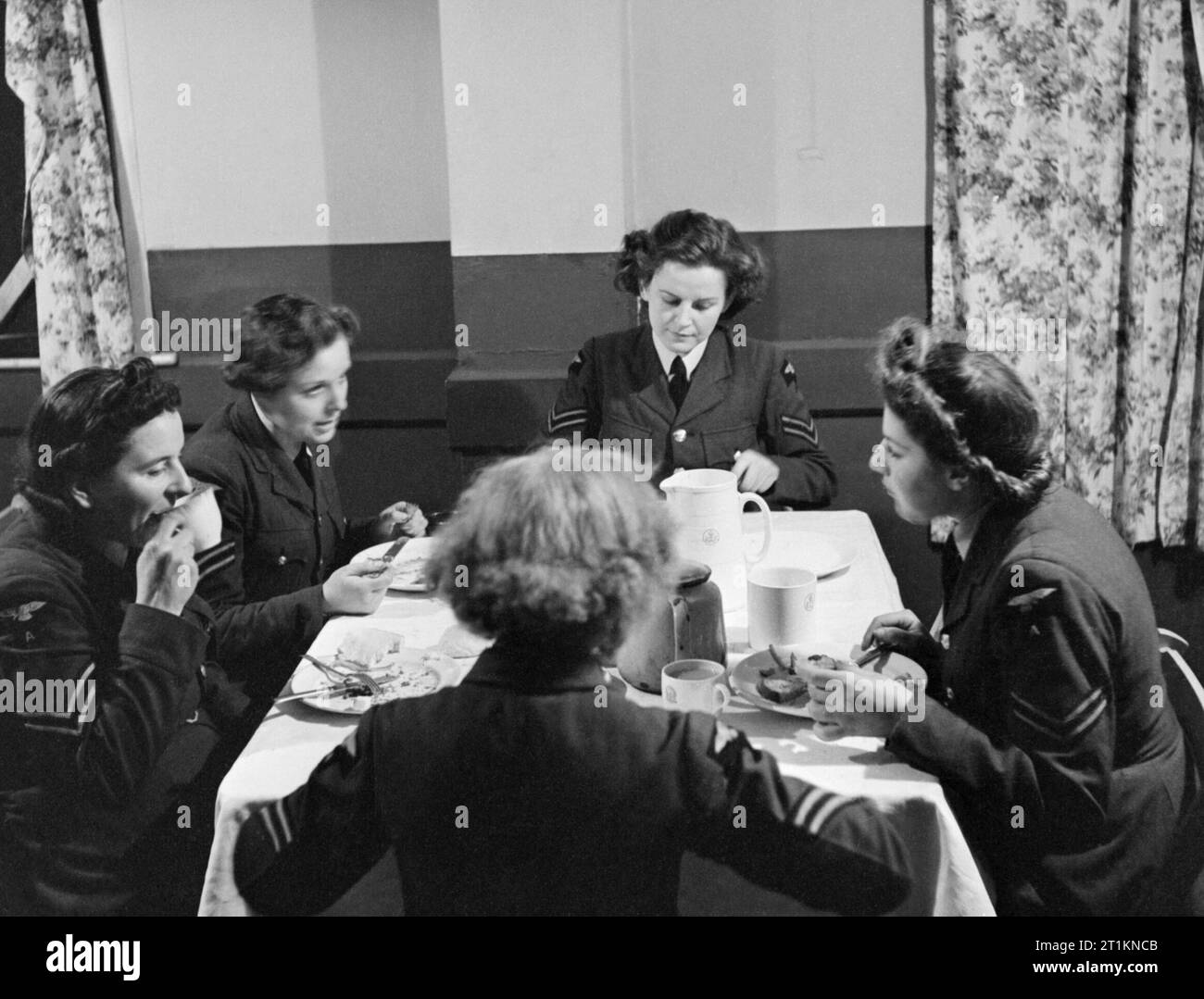 Members of the Women's Auxiliary Air Force (WAAF) enjoy a meal at a RAF ...