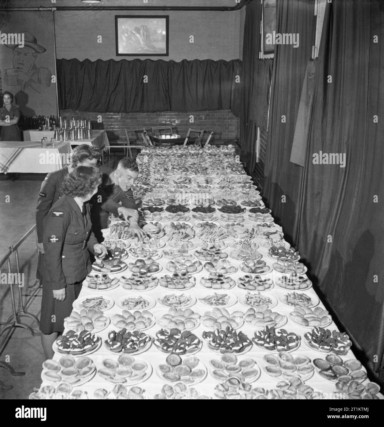 Two members of the Women's Auxiliary Air Force stop an RAF corporal ...