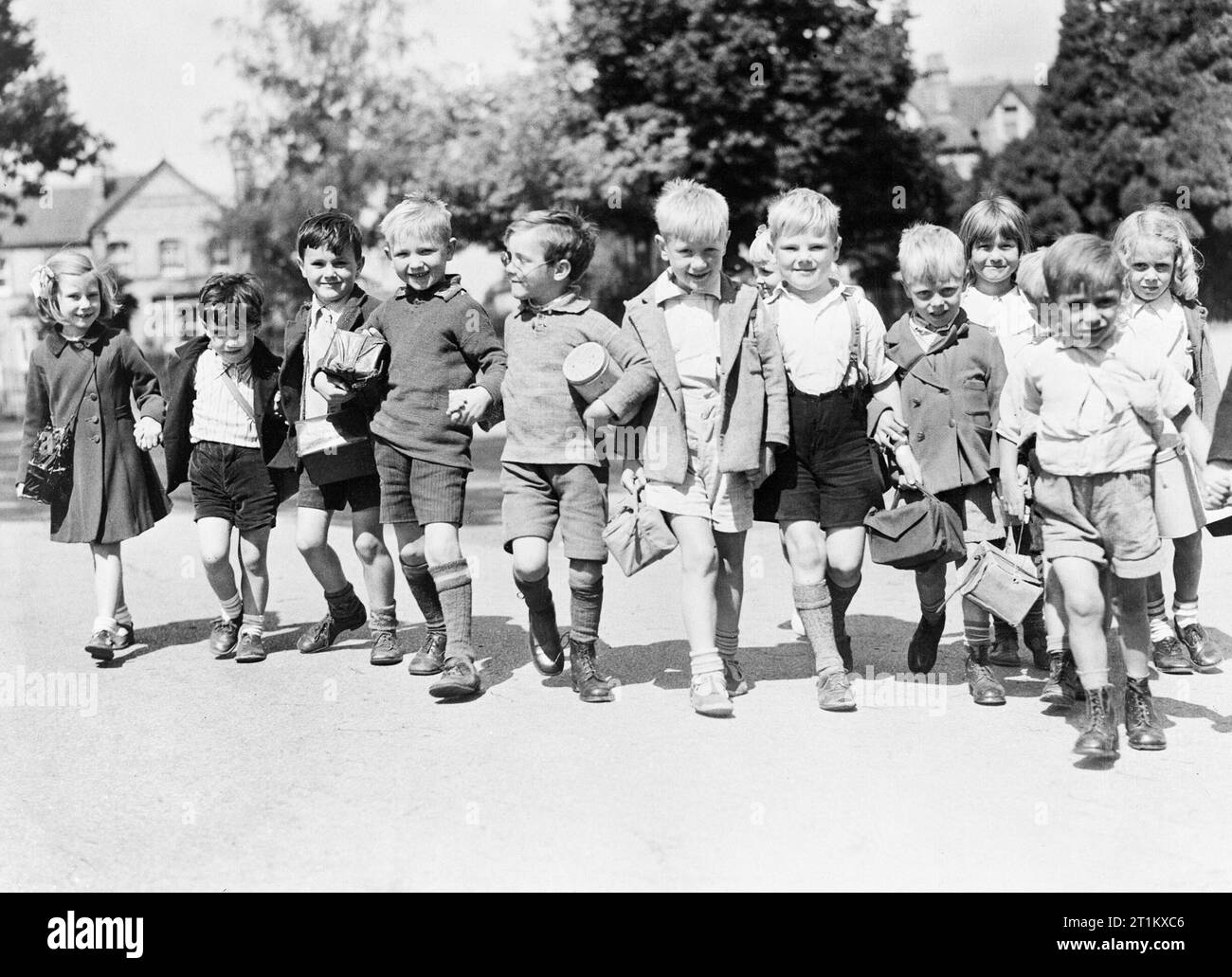 A group of smiling evacuees from Rotherhithe in Kent with gas mask ...