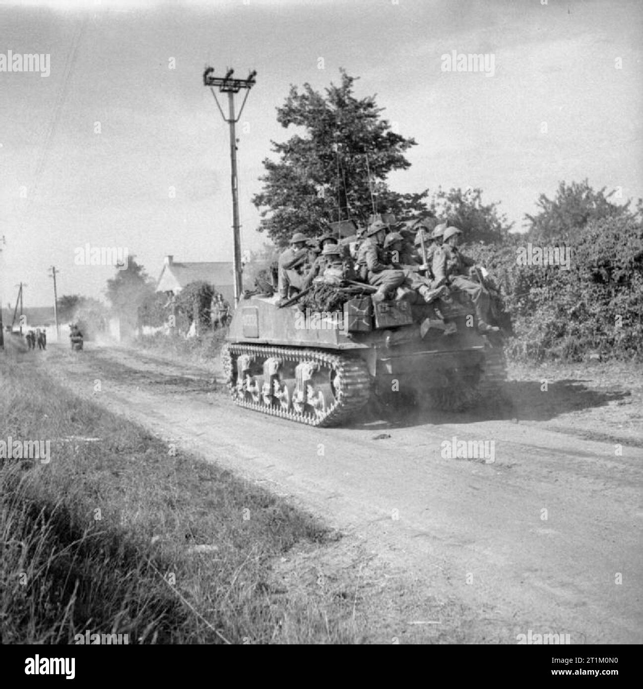 The British Army in Normandy 1944 Sherman tanks carrying infantry move ...