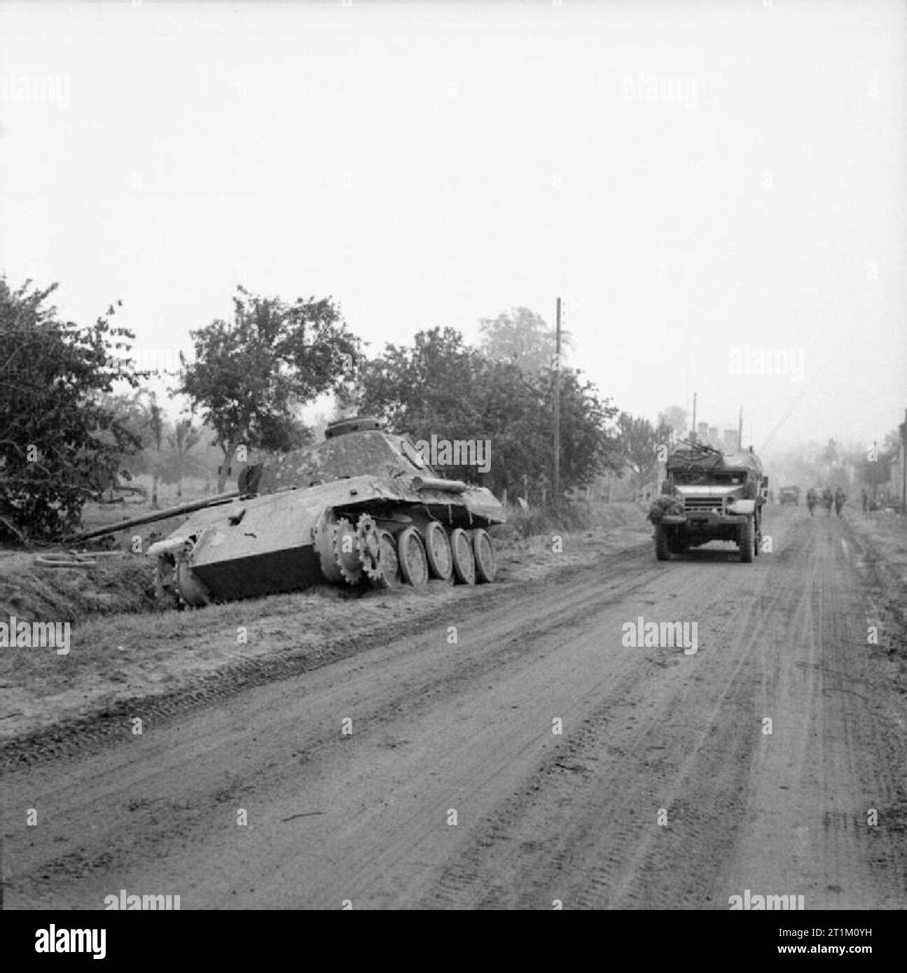 The British Army in Normandy 1944 A half-track passes a knocked-out ...