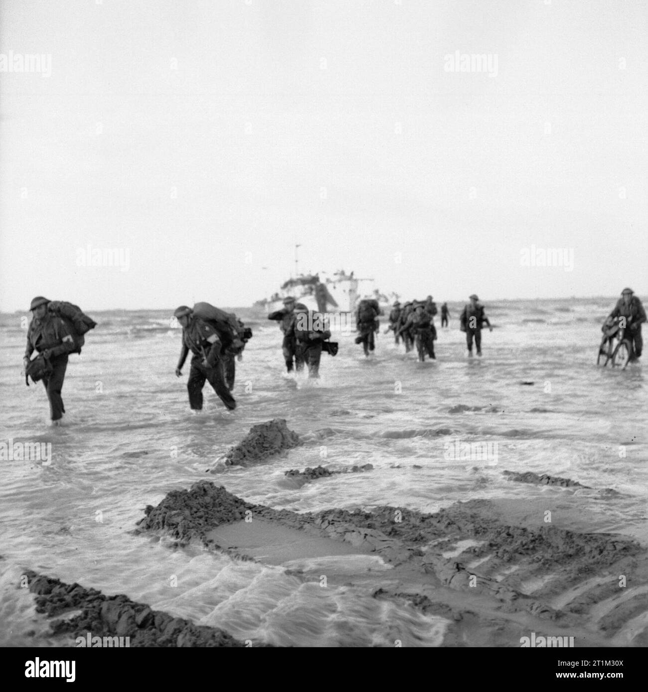 Follow-up troops wade ashore from landing craft on Queen sector of ...