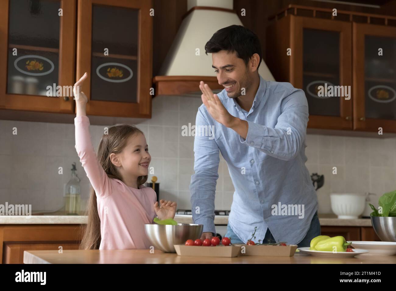 Happy child girl and handsome dad giving high five Stock Photo - Alamy