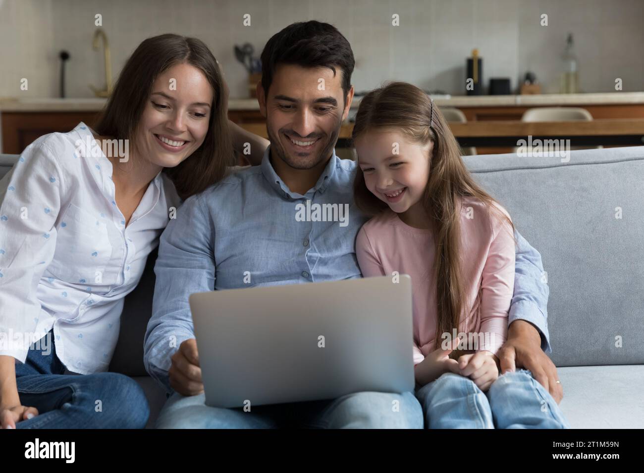Happy cheerful little kid with mom ad dad watching movie Stock Photo ...