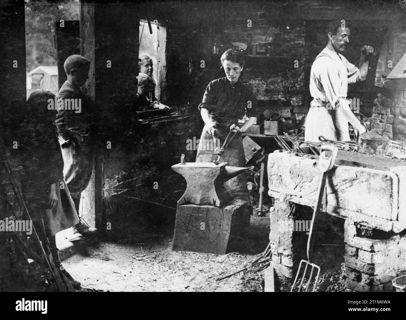 Ministry of Information First World War Official Collection Woman helping her blacksmith husband ...