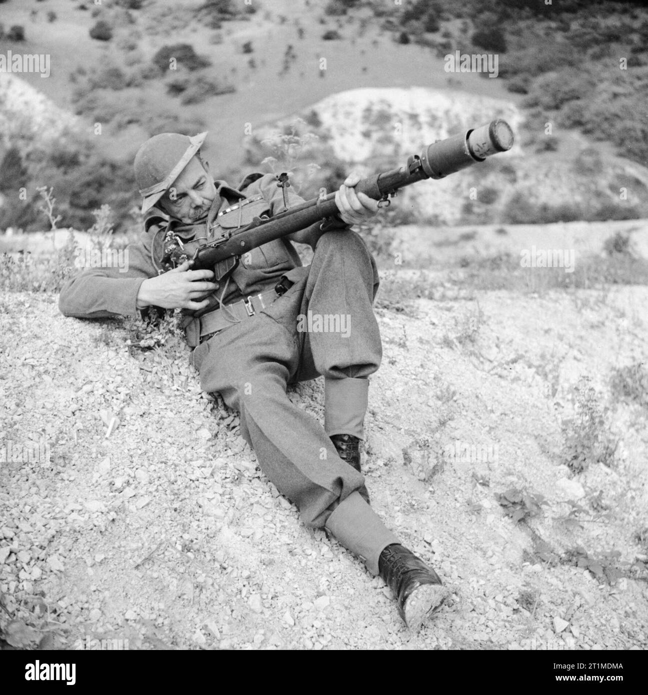 A member of the Home Guard demonstrates a rifle equipped to fire an ...