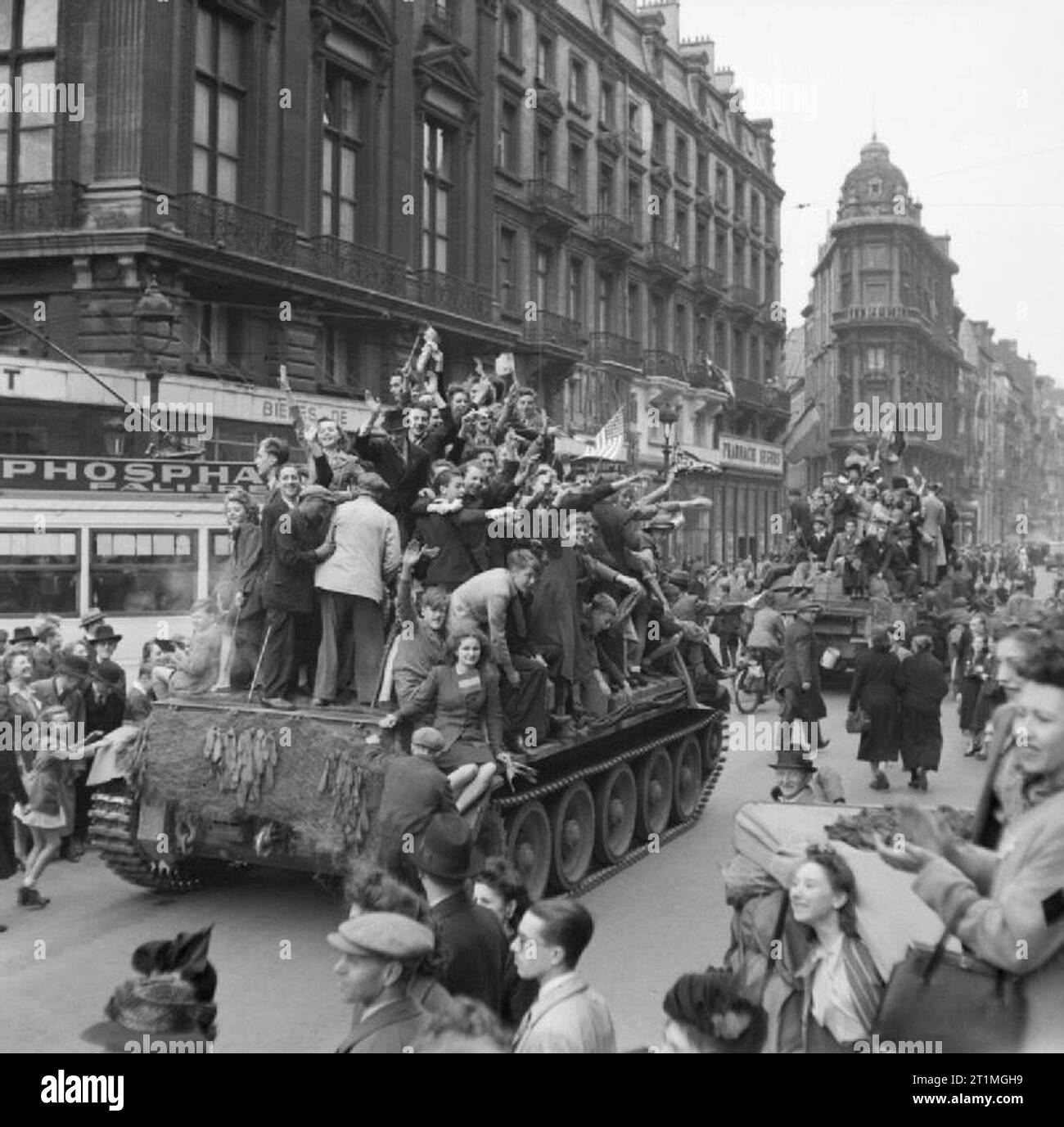 Cheering civilians ride on Cromwell tanks as British troops enter ...