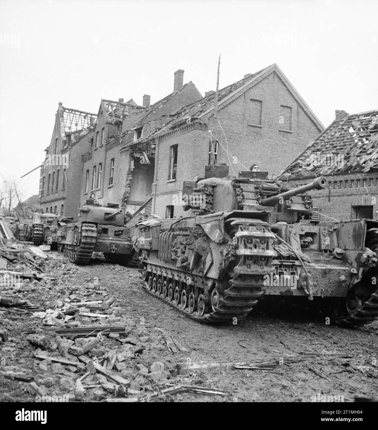 Churchill tanks drive along a badly damaged street in Kleve, Germany ...