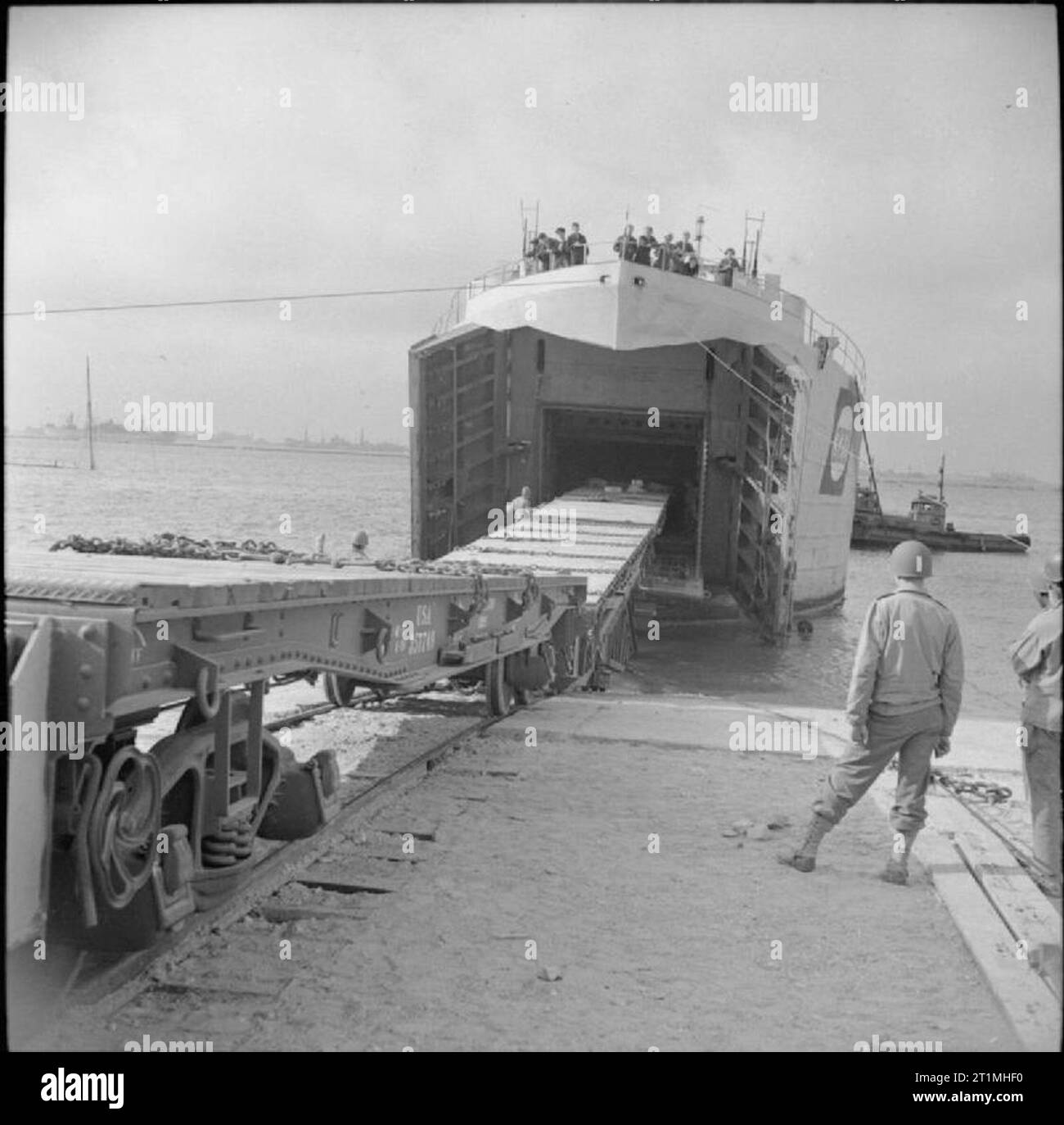 Lst 323 Flat bed railway trucks being loaded through the bow doors ...