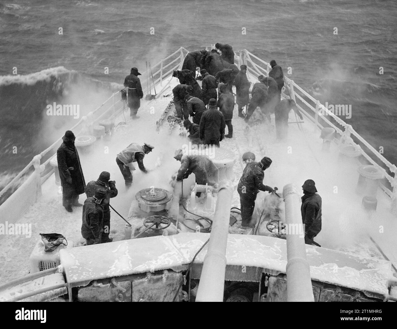 Sailors using steam hoses to clear ice from anchor chains and winches ...