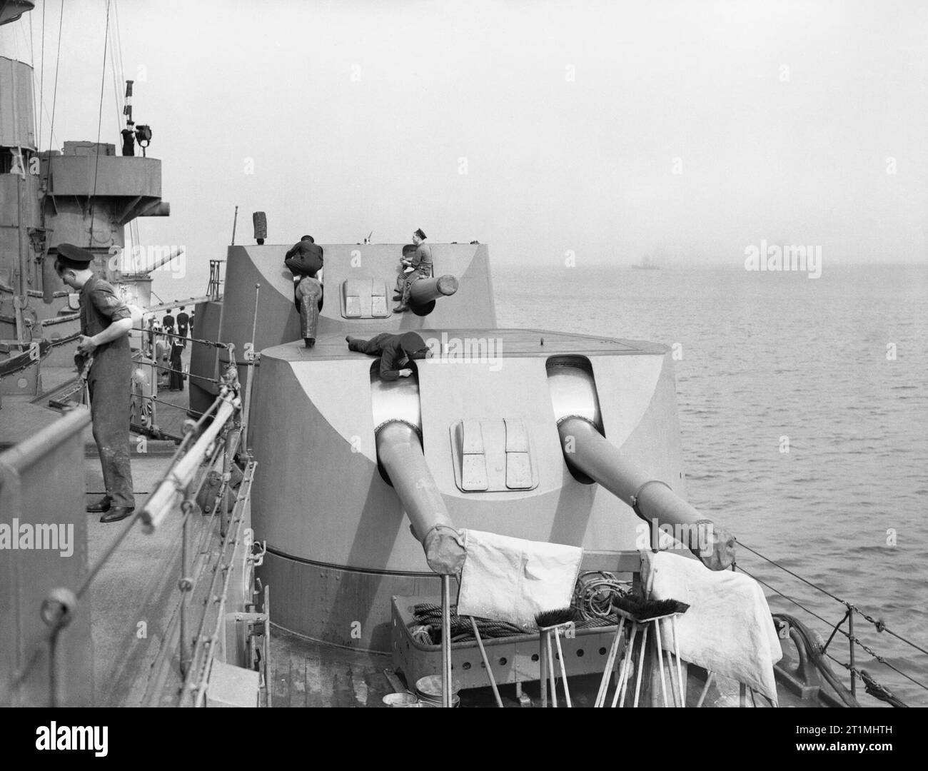 Sailors oiling and cleaning the splinter shields on the twin 6-inch gun ...