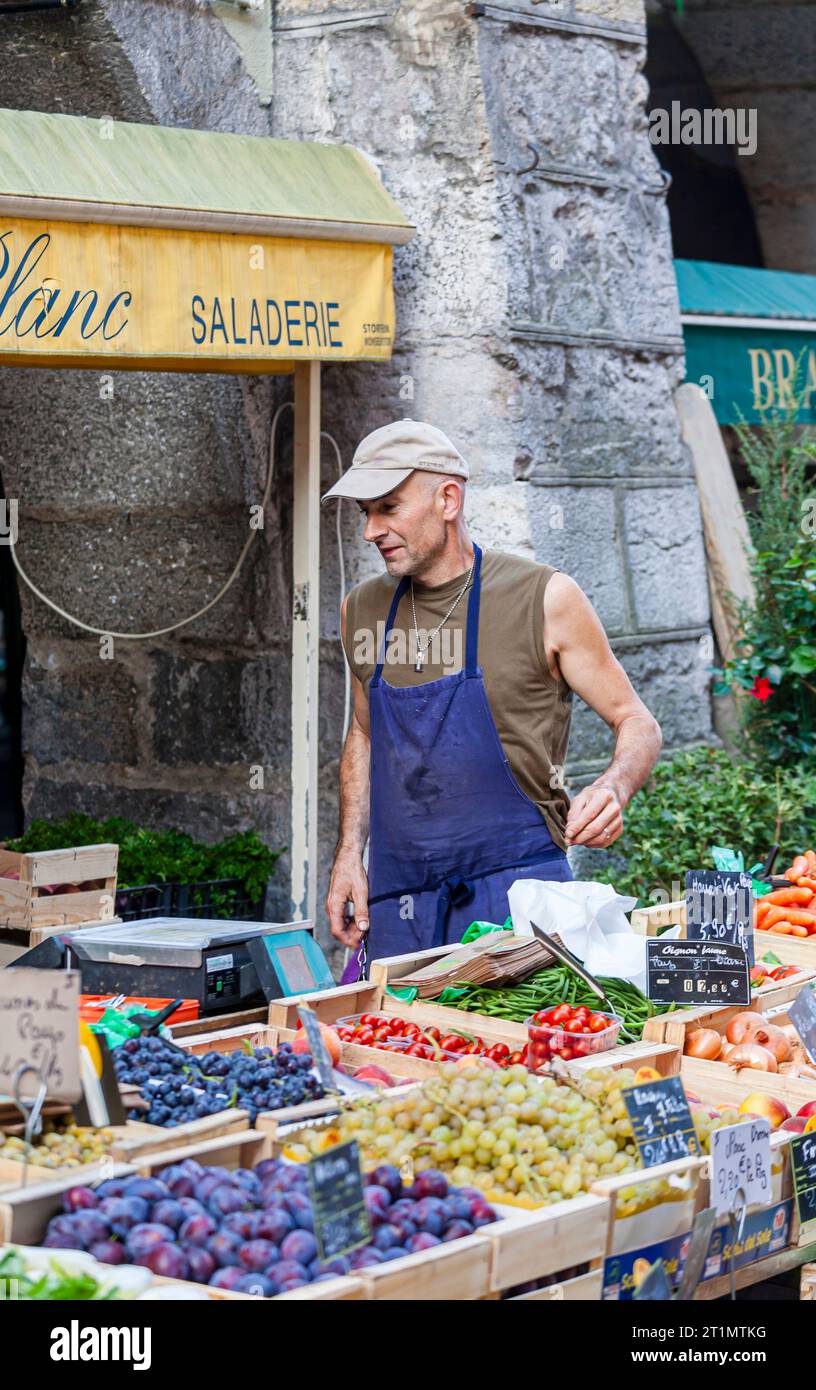 A local French male stallholder tends his fresh fruit, vegetables and ...