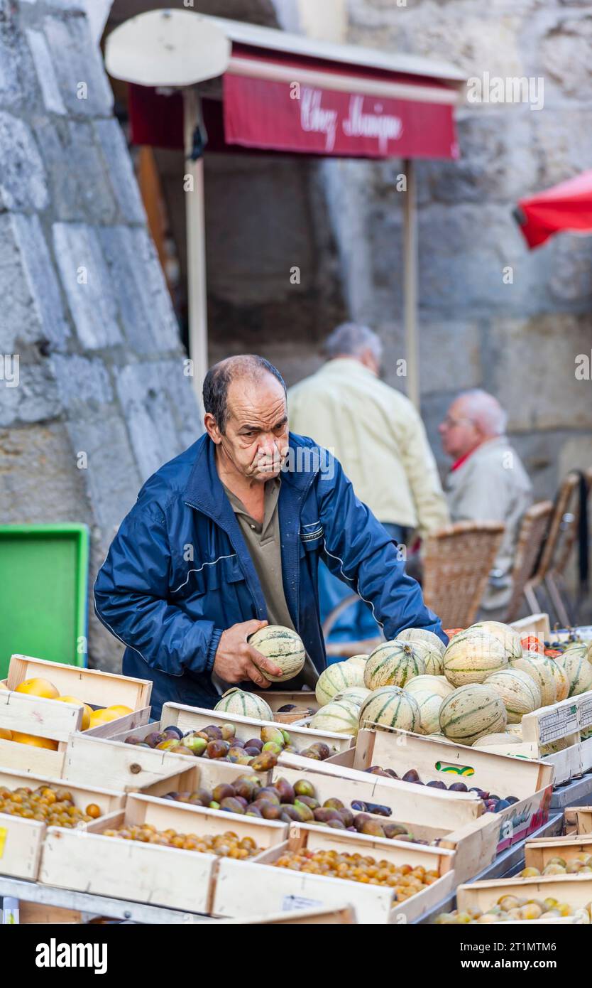 A local French male stallholder tends his fresh fruit, vegetables and ...