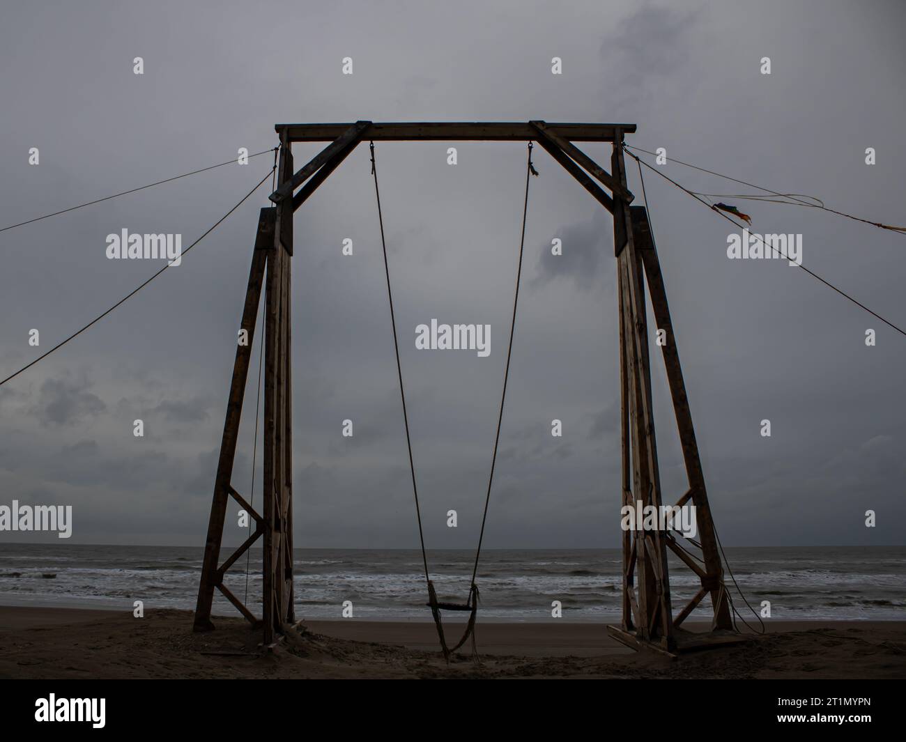 Single swing on the beach in dark and moody weather Stock Photo - Alamy