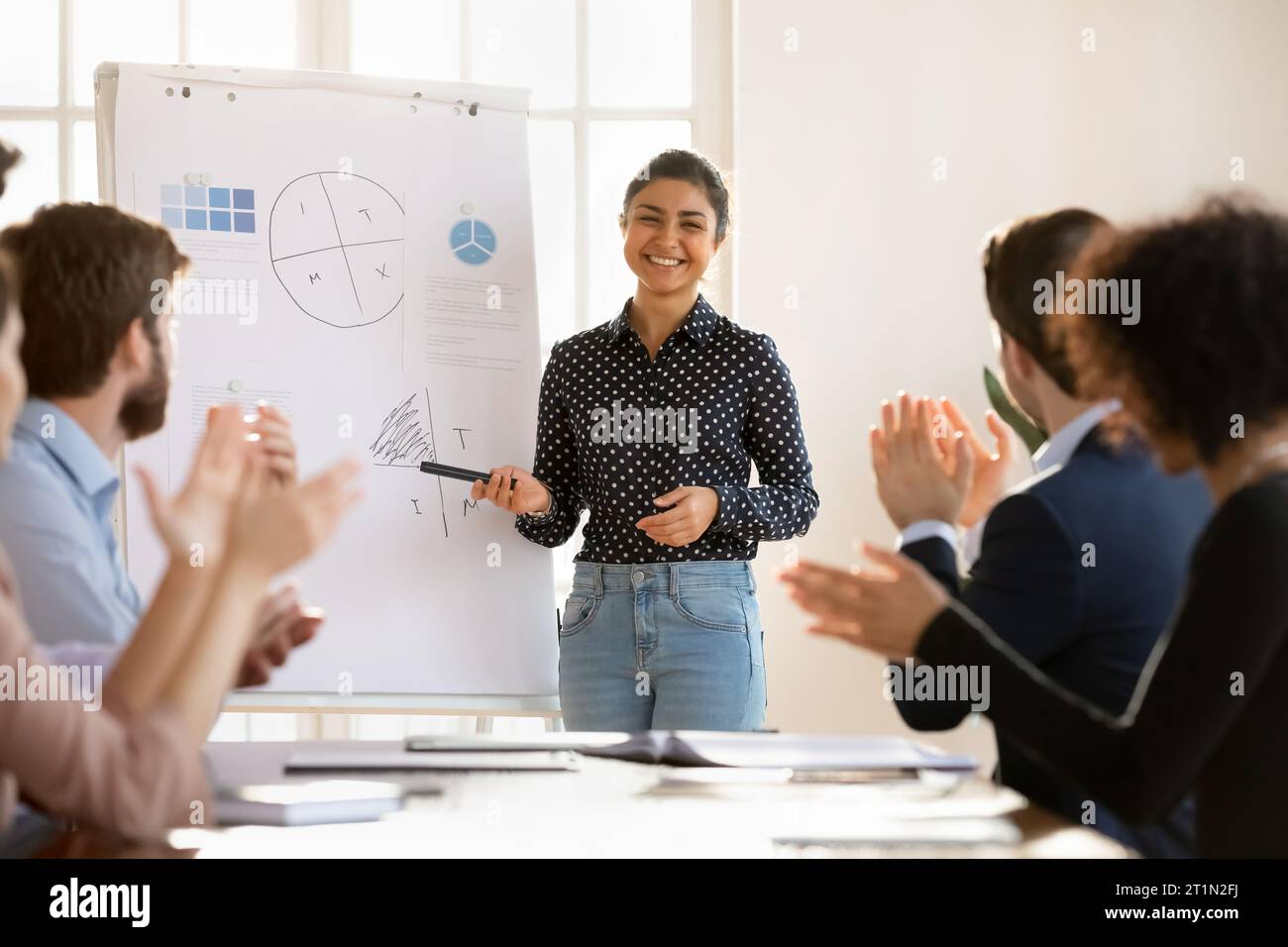 Business audience applauding happy pretty young Indian presenter Stock ...