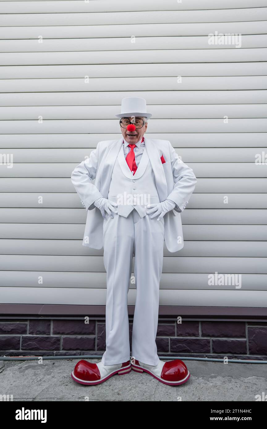 Full-length portrait of a clown in a white classic suit and a vintage ...