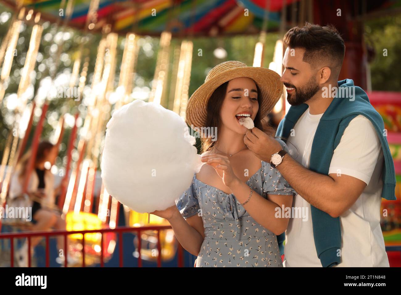 Young man feeding his girlfriend with cotton candy at funfair Stock ...