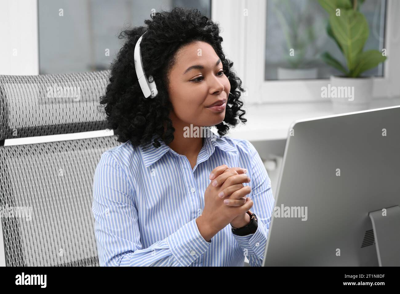 Young female employee in headphones hi-res stock photography and images ...
