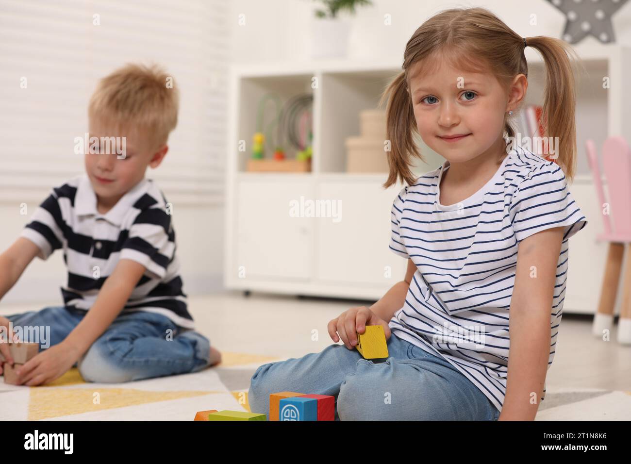 Little children playing with building blocks indoors. Wooden toys Stock ...