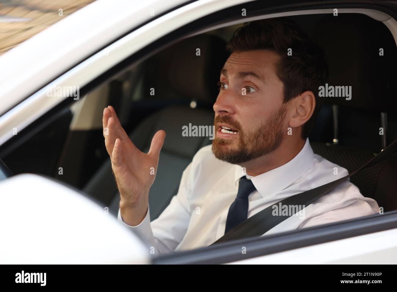 Stressed driver in his car, view from outside. Stuck in traffic jam ...