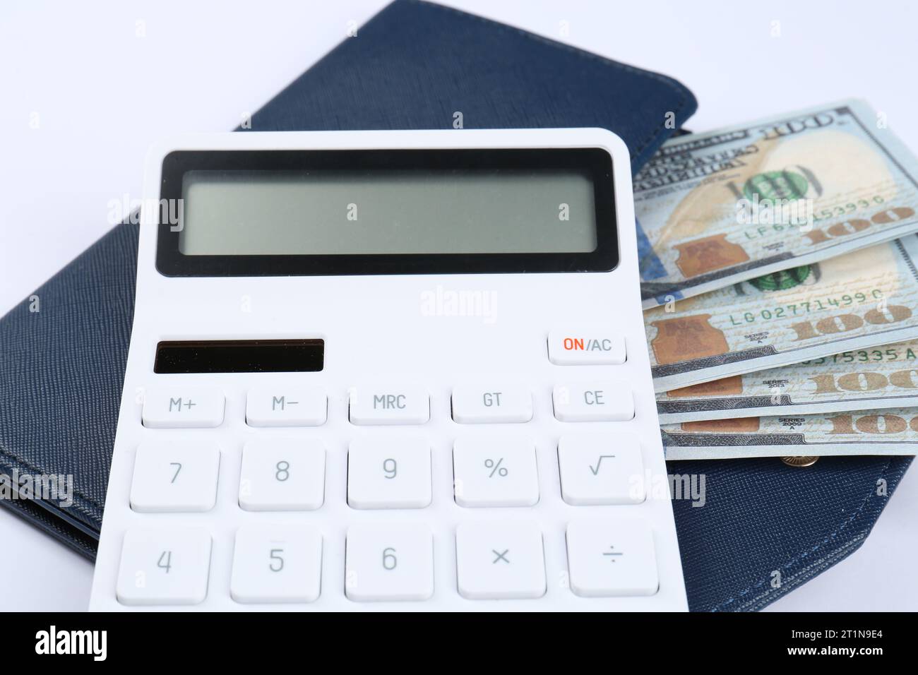 Calculator, dollar banknotes and wallet on white background, closeup ...