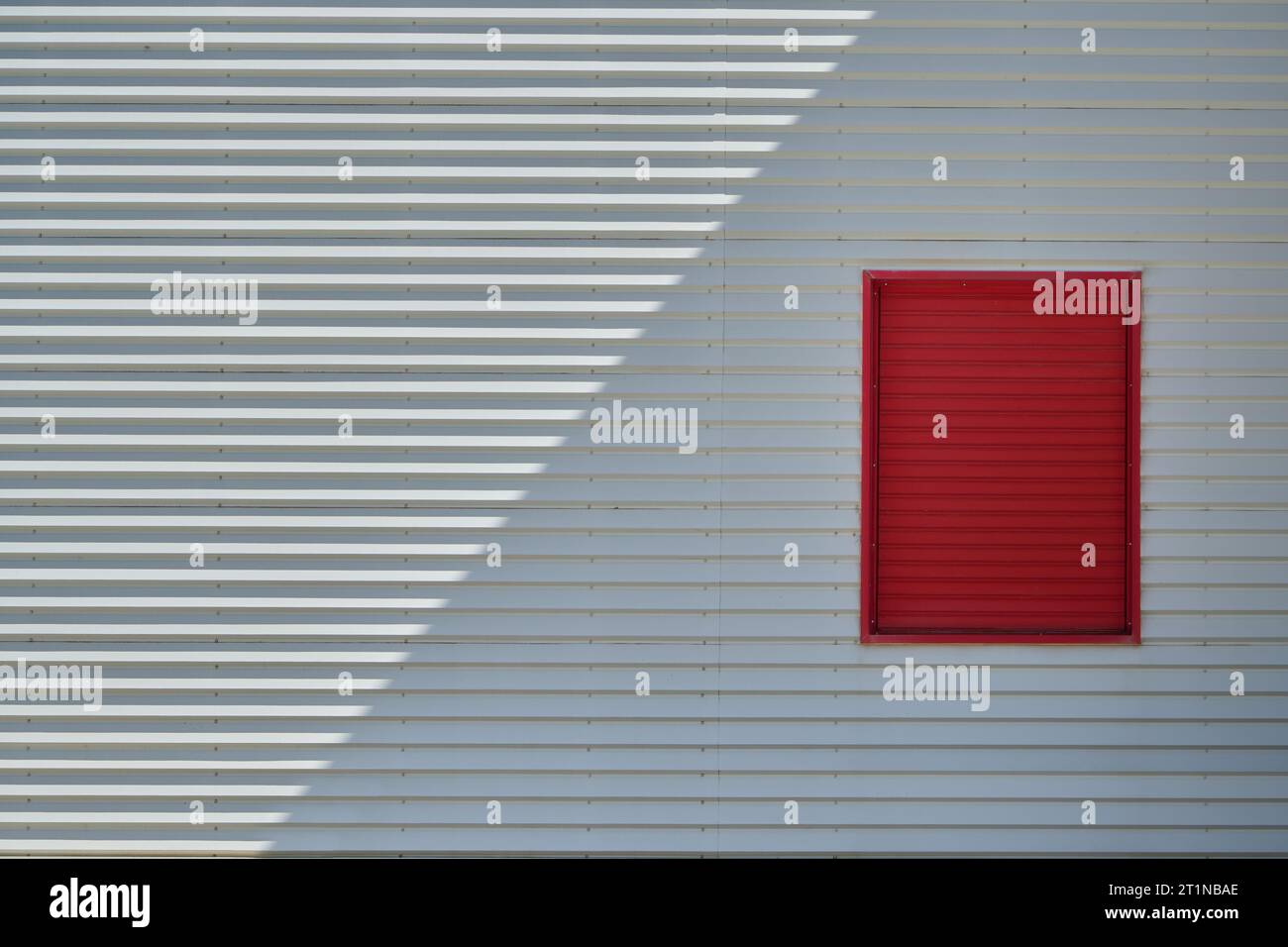 Red window on white industrial metallic textured facade Stock Photo - Alamy