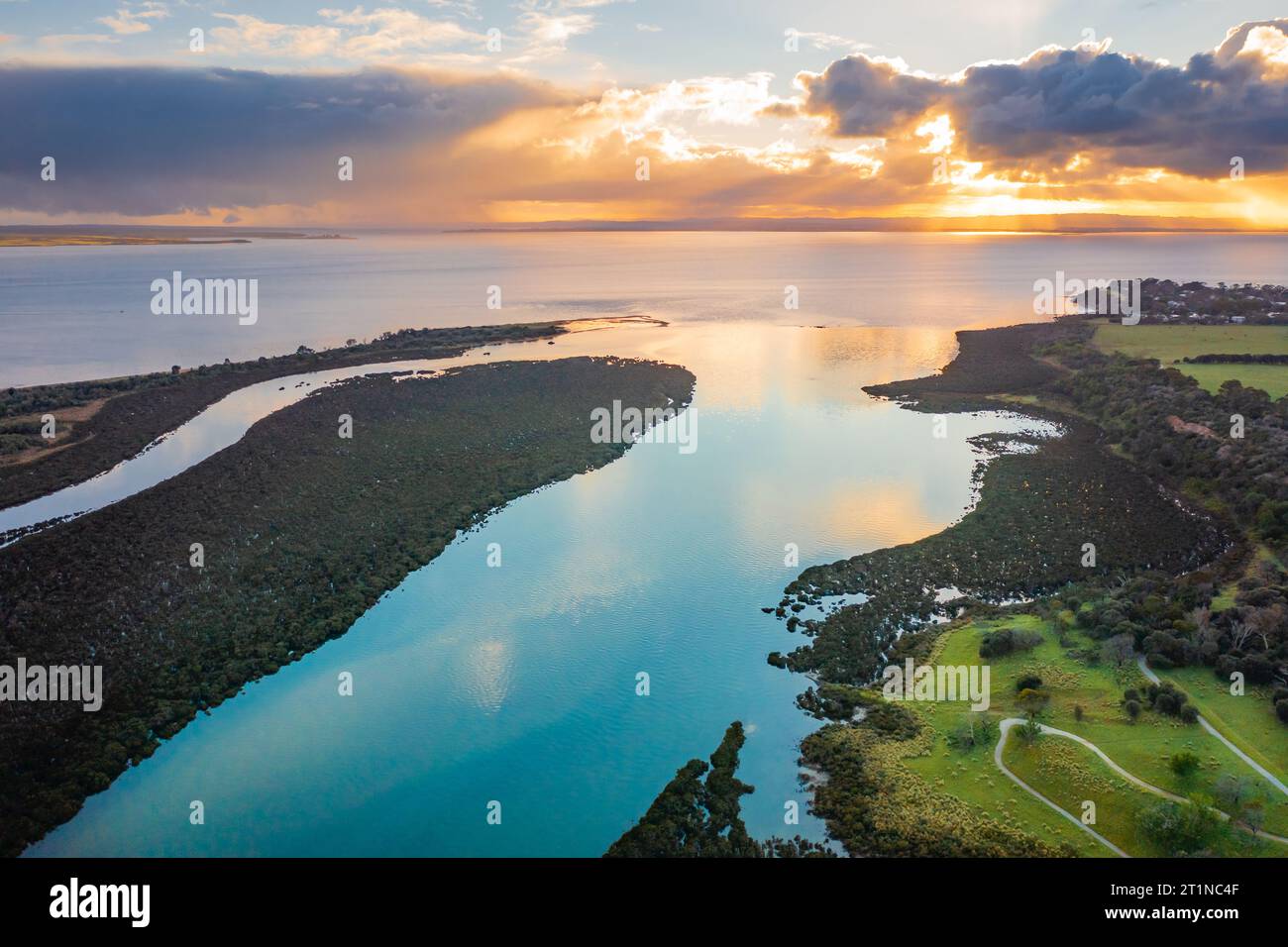 Aerial view of a coastal inlet going out to sea at sunrise at the Rhyll ...