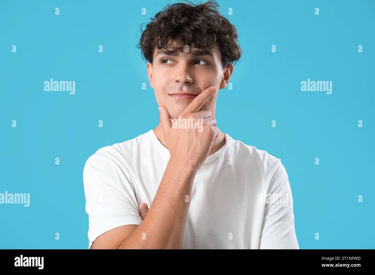 Portrait of pondering young man on blue background Stock Photo - Alamy