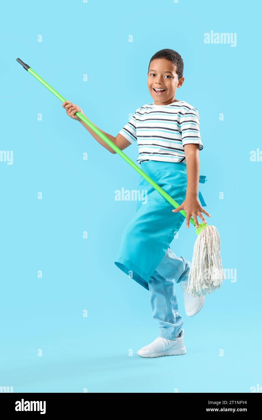 Cute little African-American boy with mop on blue background Stock ...