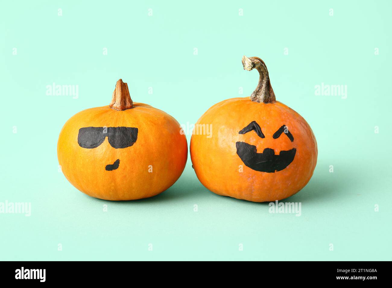 Funny Halloween pumpkins with drawn faces on turquoise background Stock ...