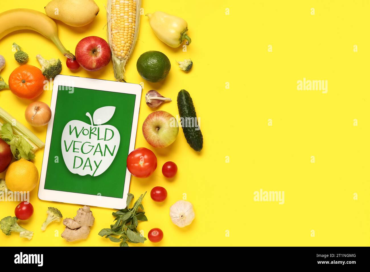 Tablet computer with text WORLD VEGAN DAY, fresh vegetables and fruits ...