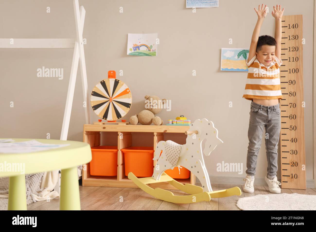 Little Asian boy measuring height at home Stock Photo - Alamy