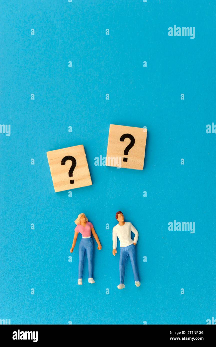 woman and man miniature figurine and question marks symbols Stock Photo ...