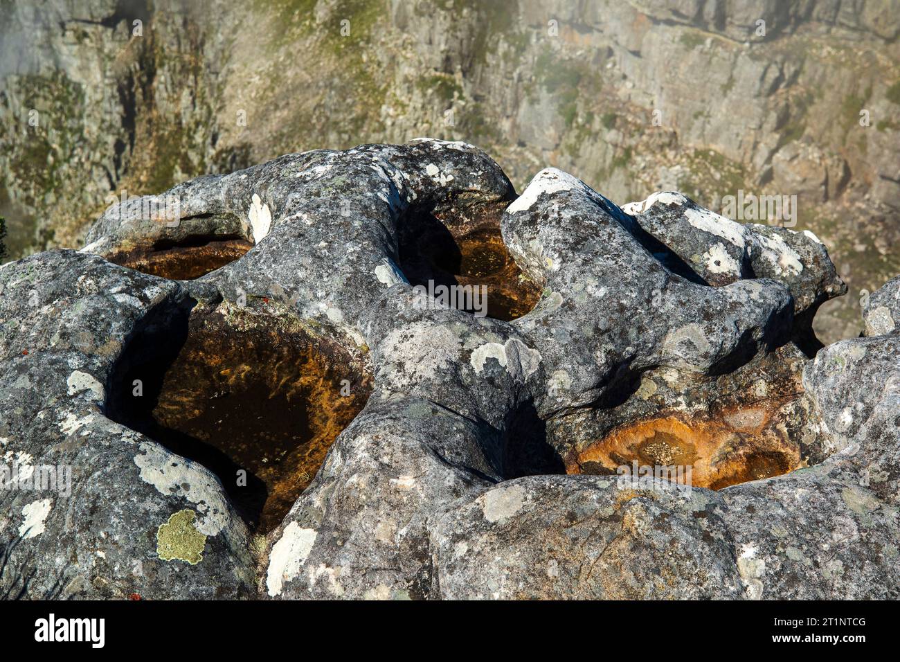 Multi-colored stone with puddle in the holes Stock Photo - Alamy