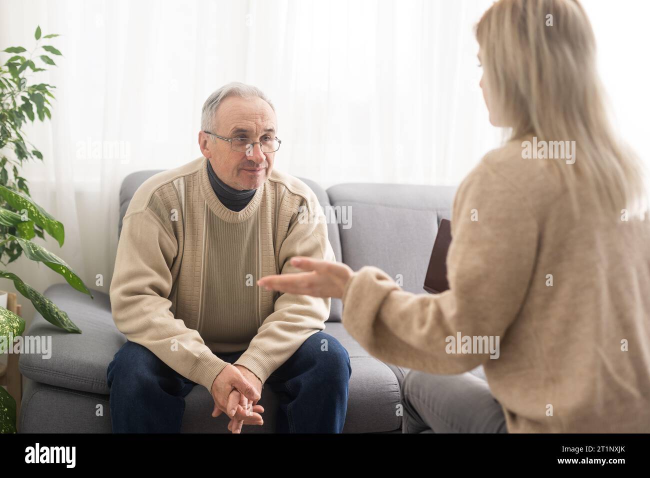 Senior man patient and young woman caregiver medical worker in uniform ...