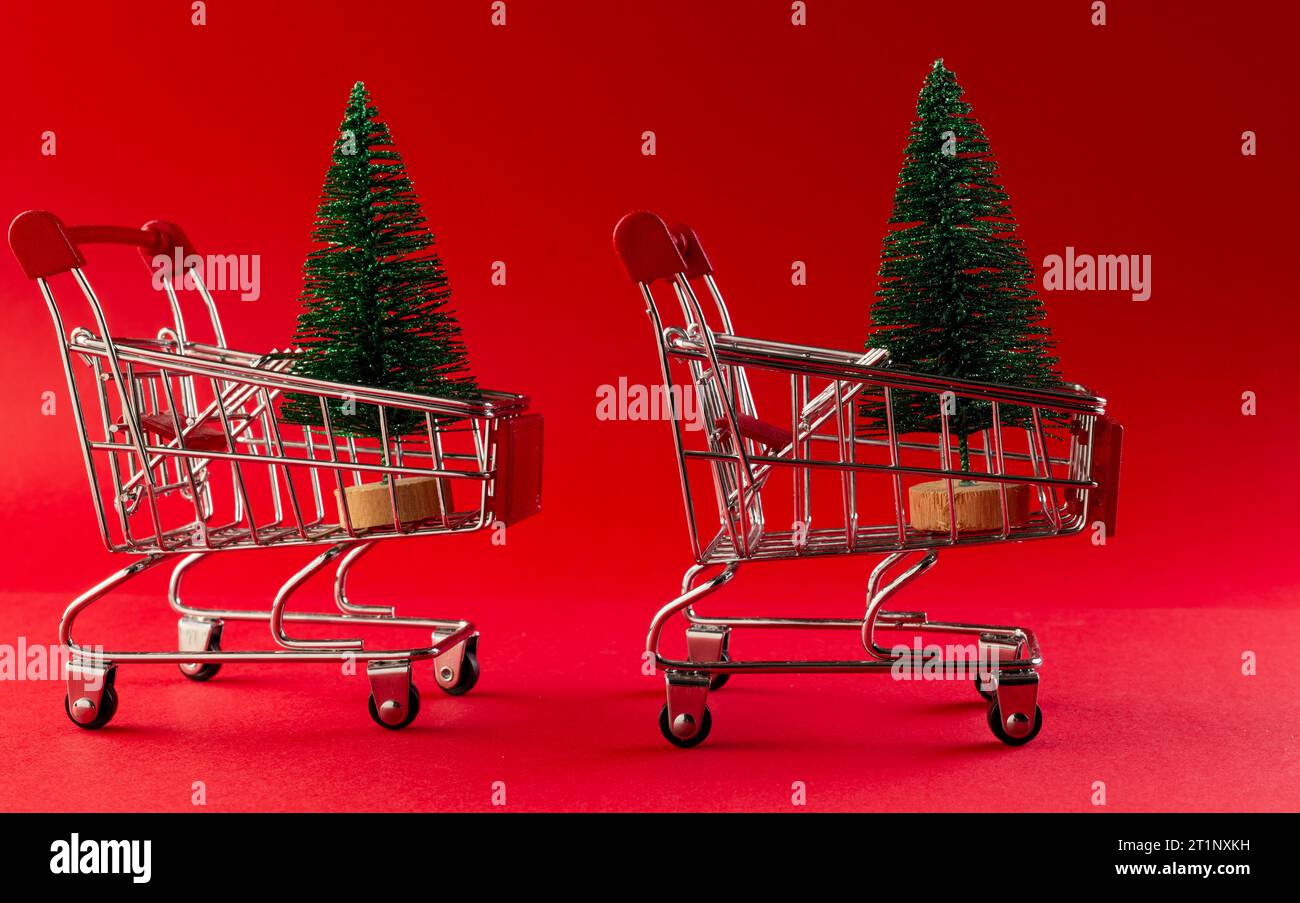 Shopping trolleys with christmas trees with copy space on red ...