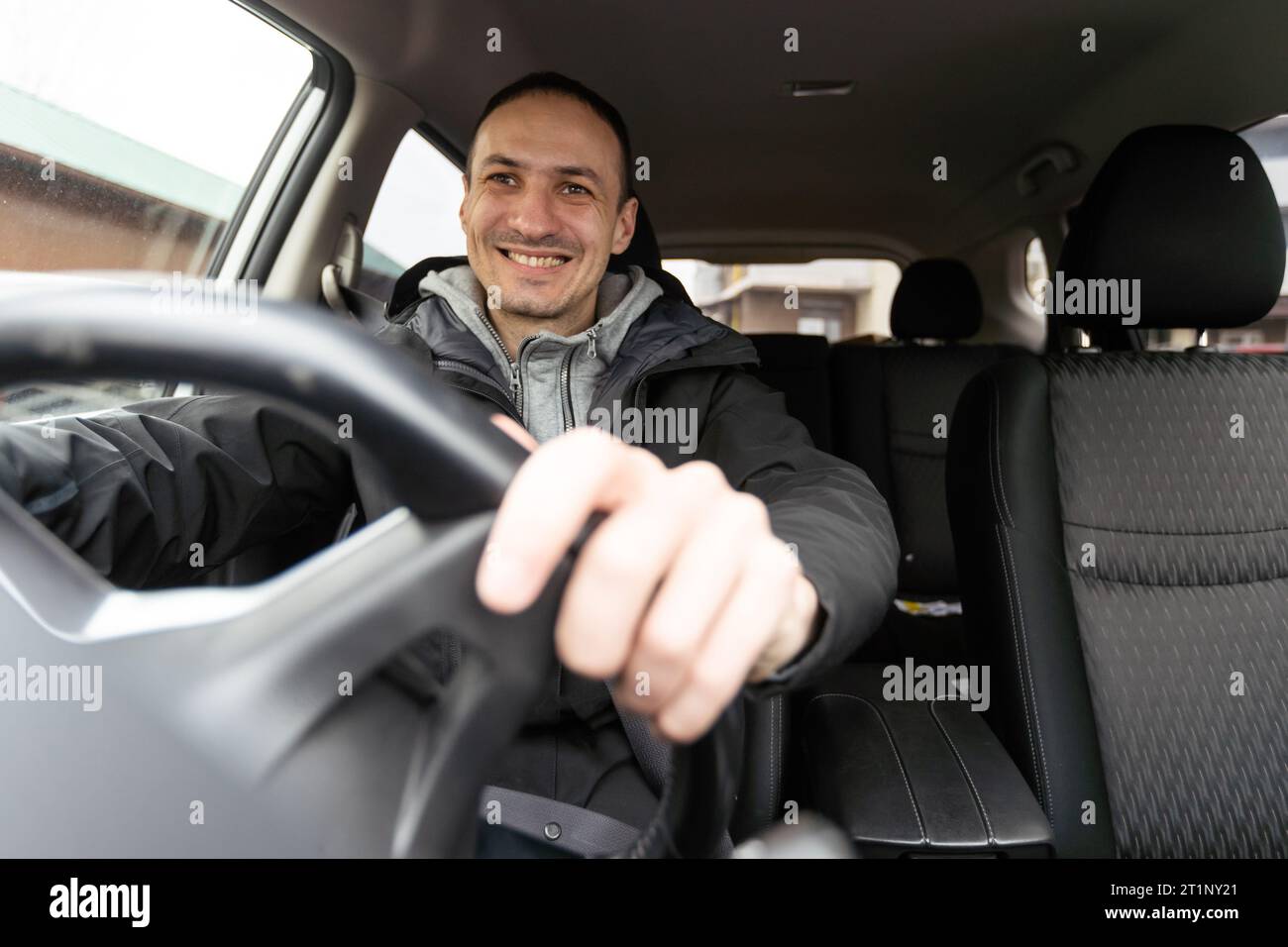 My baby. Shot of a happy man sitting in his car touching the dashboard ...