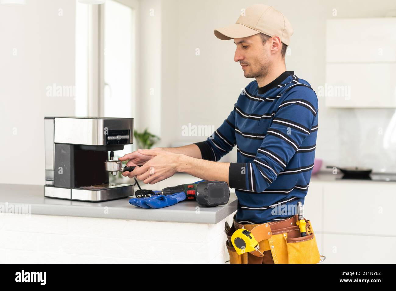 professional young worker fixing coffee machine Stock Photo - Alamy