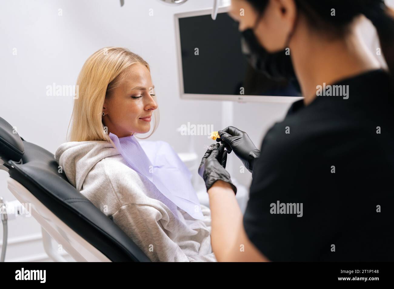 Side view of unrecognizable female orthodontist doctor showing aligners ...
