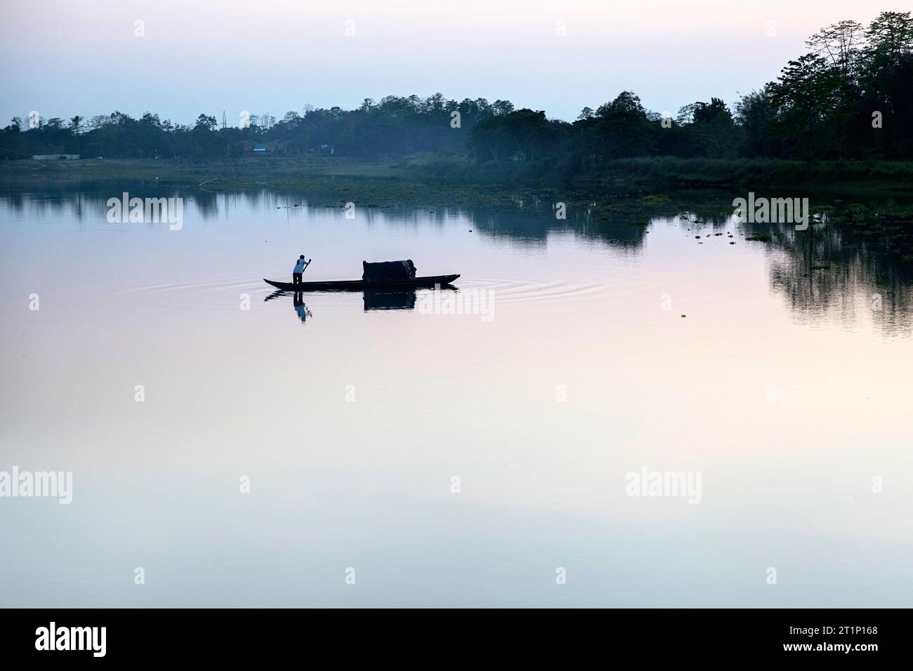A local fisherman on back of a traditional fishing dugout canoe, rowing ...