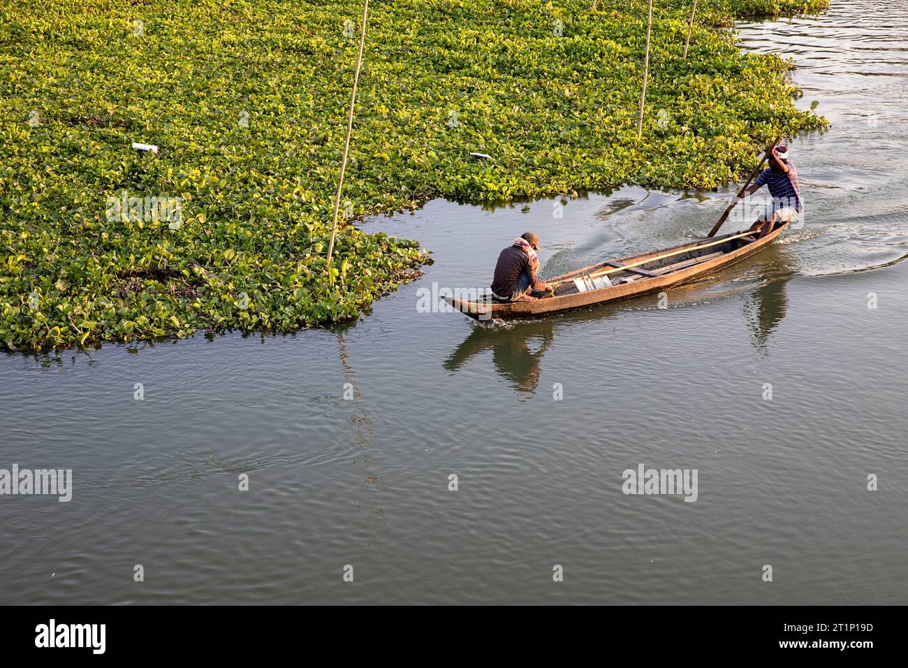Fisherman paddling in a traditional wooden fishing boat, dugout canoe ...