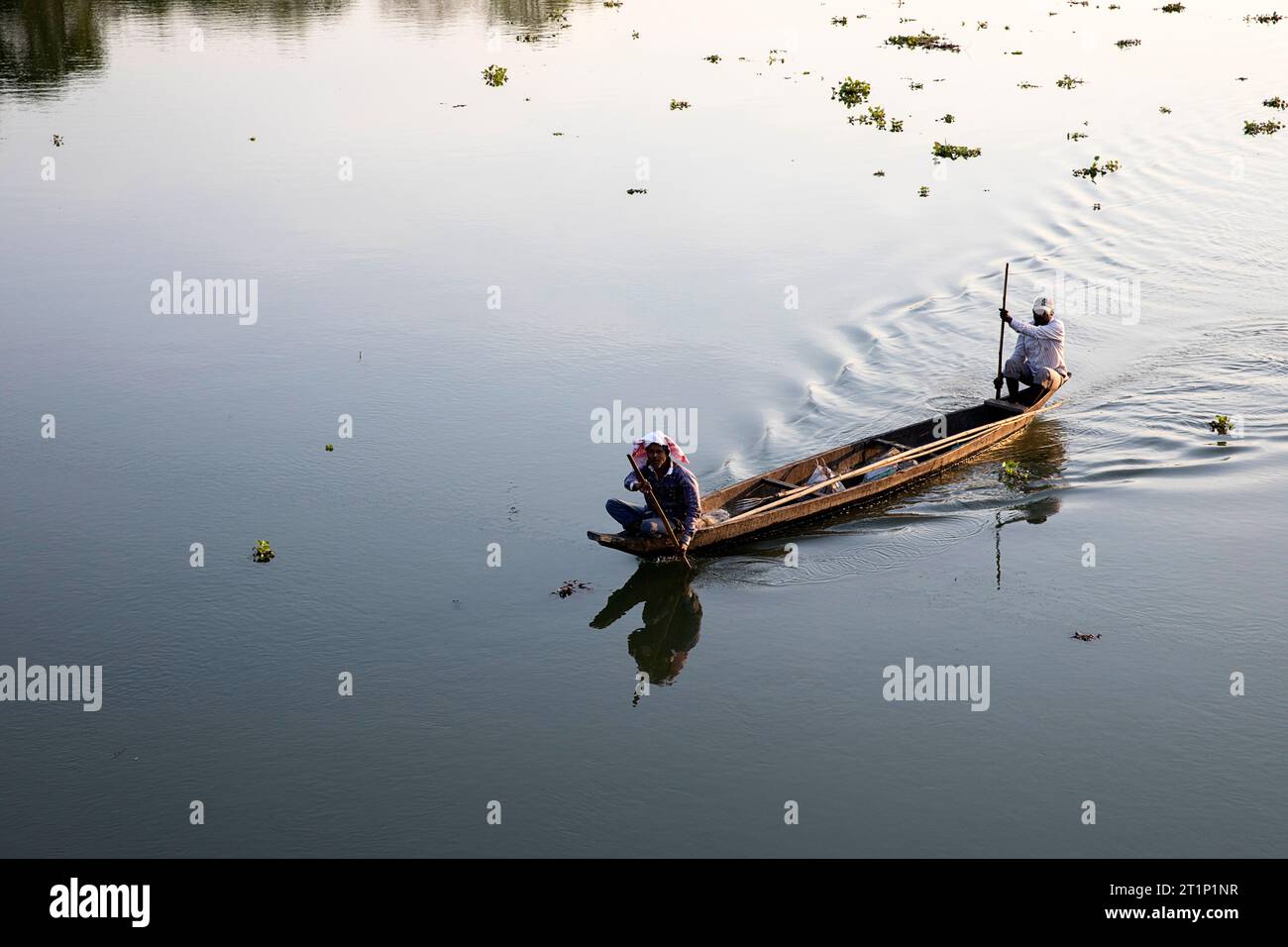 Local fishermen in a wooden traditional fishing boat on a river on ...