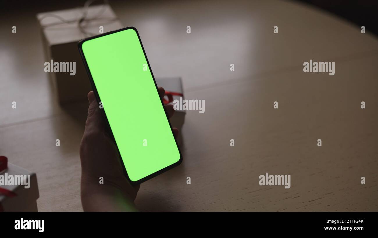 old female hands holding smartphone with green screen and celebrating ...
