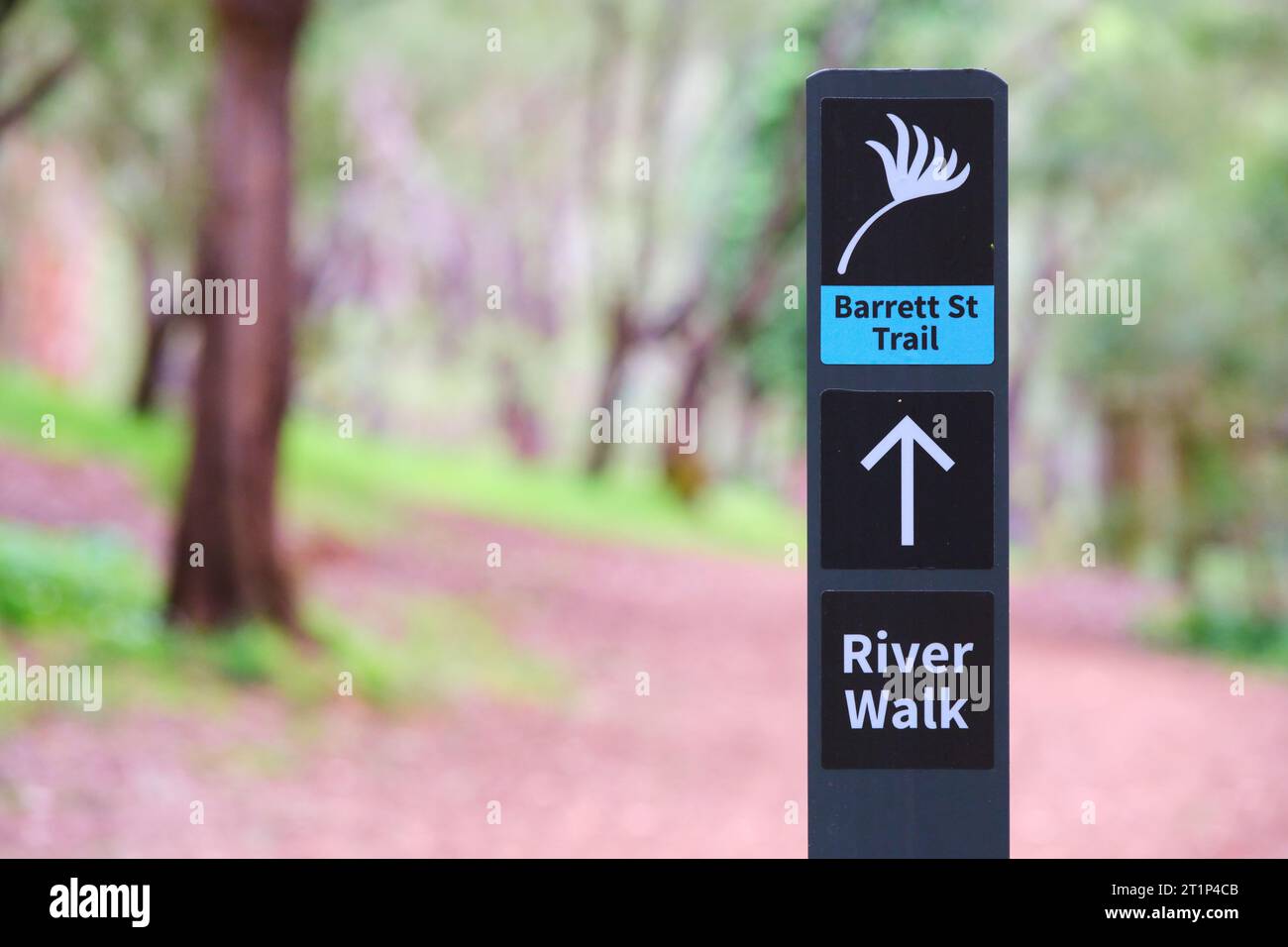 A sign indicating the Barrett Street walk trail by the river between ...
